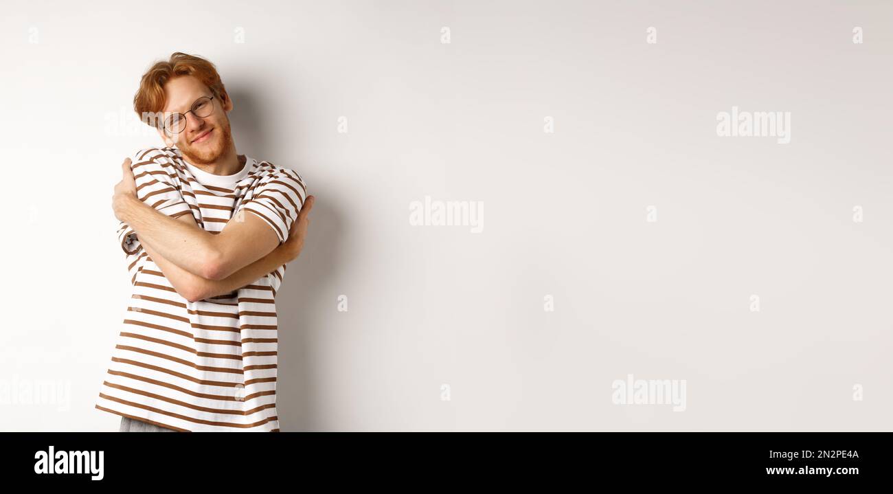 Handsome smiling man with red hair and beard looking relaxed, hugging ...