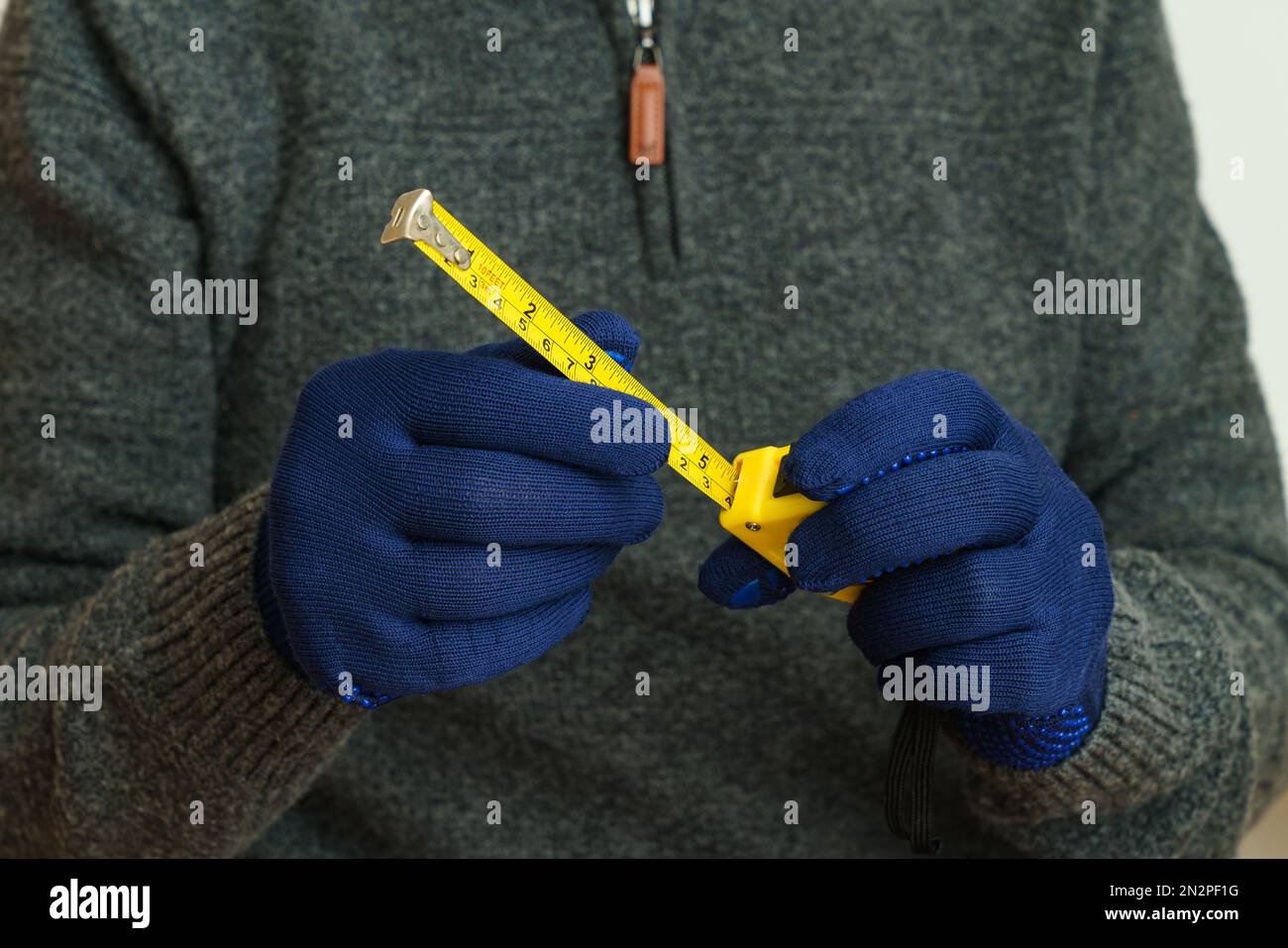 Construction worker measuring distance using tape measure building hi ...