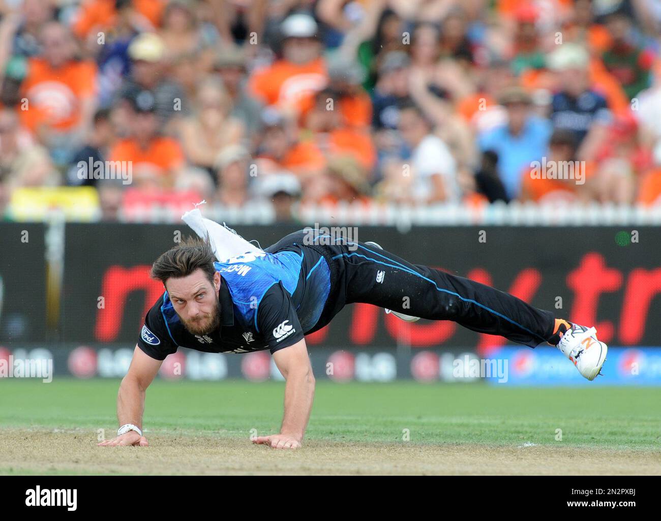 New Zealand's Mitchell McClenaghan falls while bowling during their ...