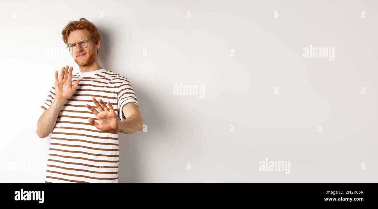 Displeased young man with red hair and bristle showing stop gesture ...