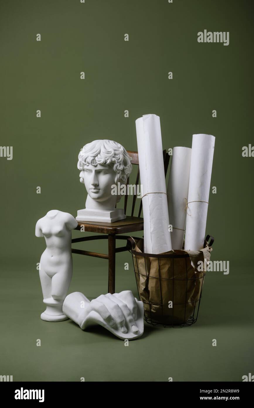 Still life of an assorted plaster figurines and rolled up artwork Stock ...