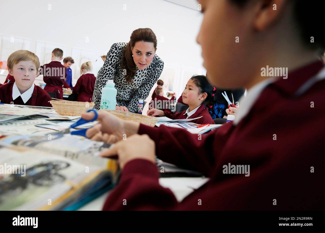 Kate, the Duchess of Cambridge, looks at art work being created by students from Holy Trinity ...