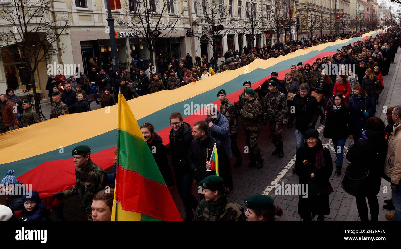 People carry a giant Lithuanian flag during a celebration of Lithuania ...