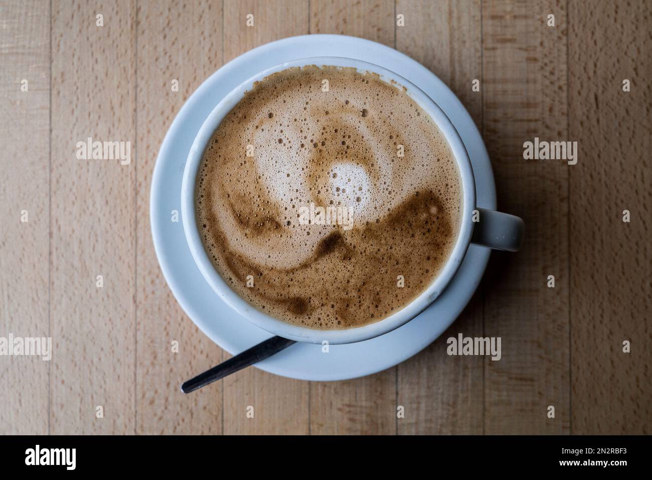 An overhead view of the froth on a fresh cup of coffee in a restaurant ...