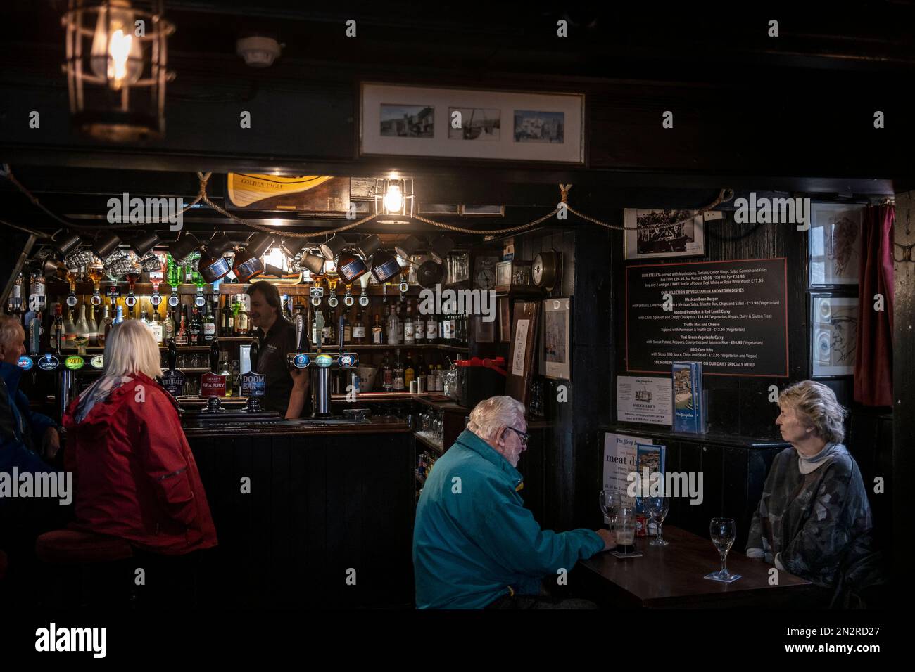 Customers relaxing inside The Sloop Inn in St Ives in Cornwall in ...