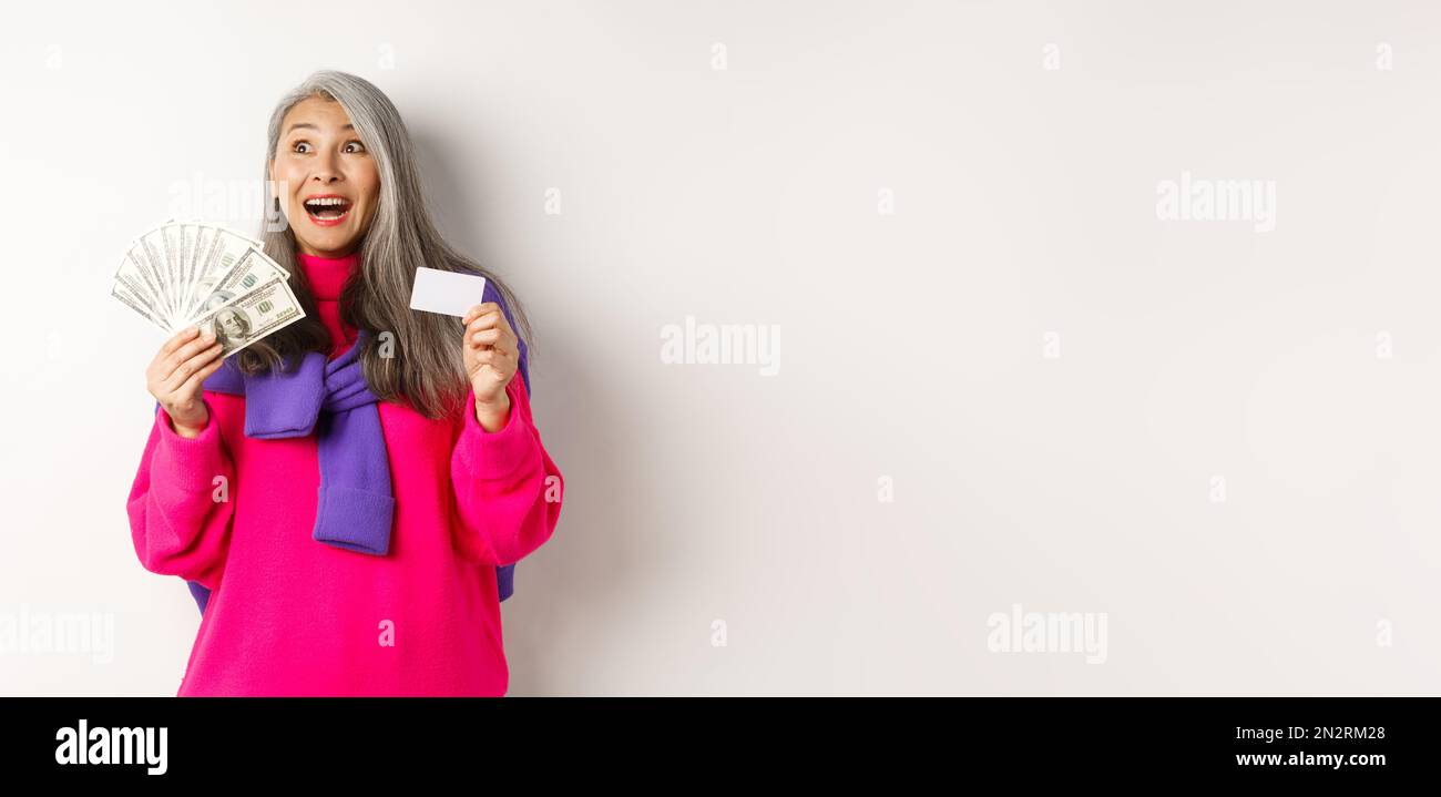 Shopping concept. Happy asian old woman with grey hair, looking ...