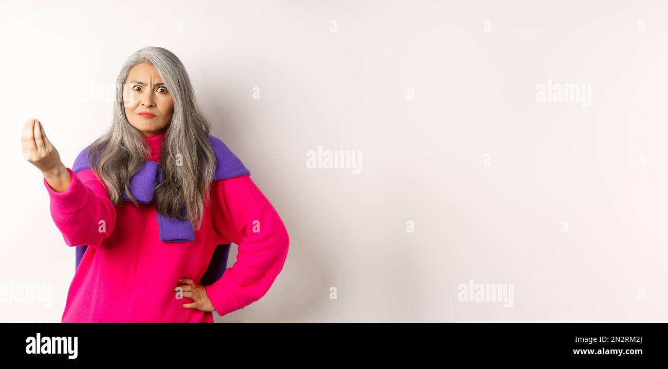 Funny asian woman staring angry and confused, shaking fingers, standing ...