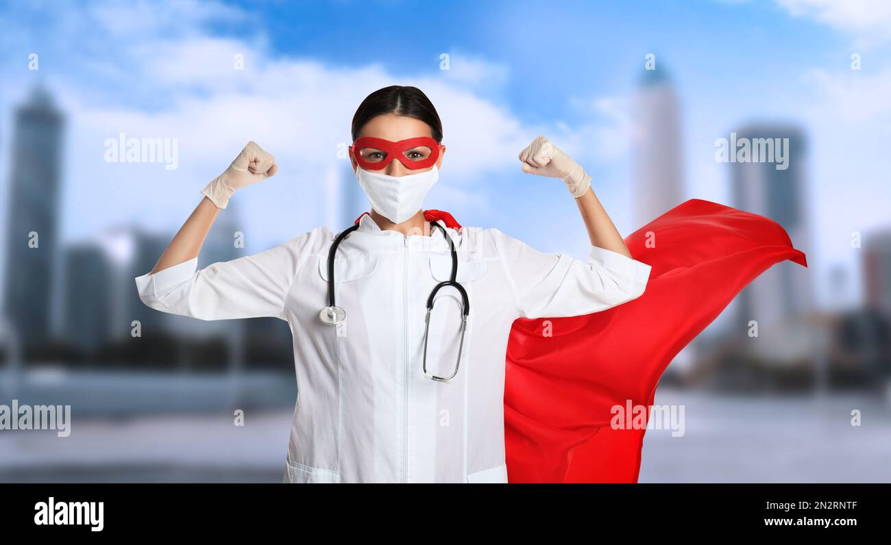 Doctor dressed as superhero on city background. Medical workers ...