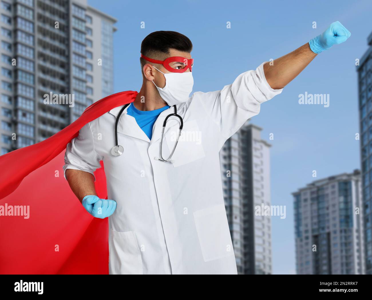 Doctor dressed as superhero on city background. Medical workers ...