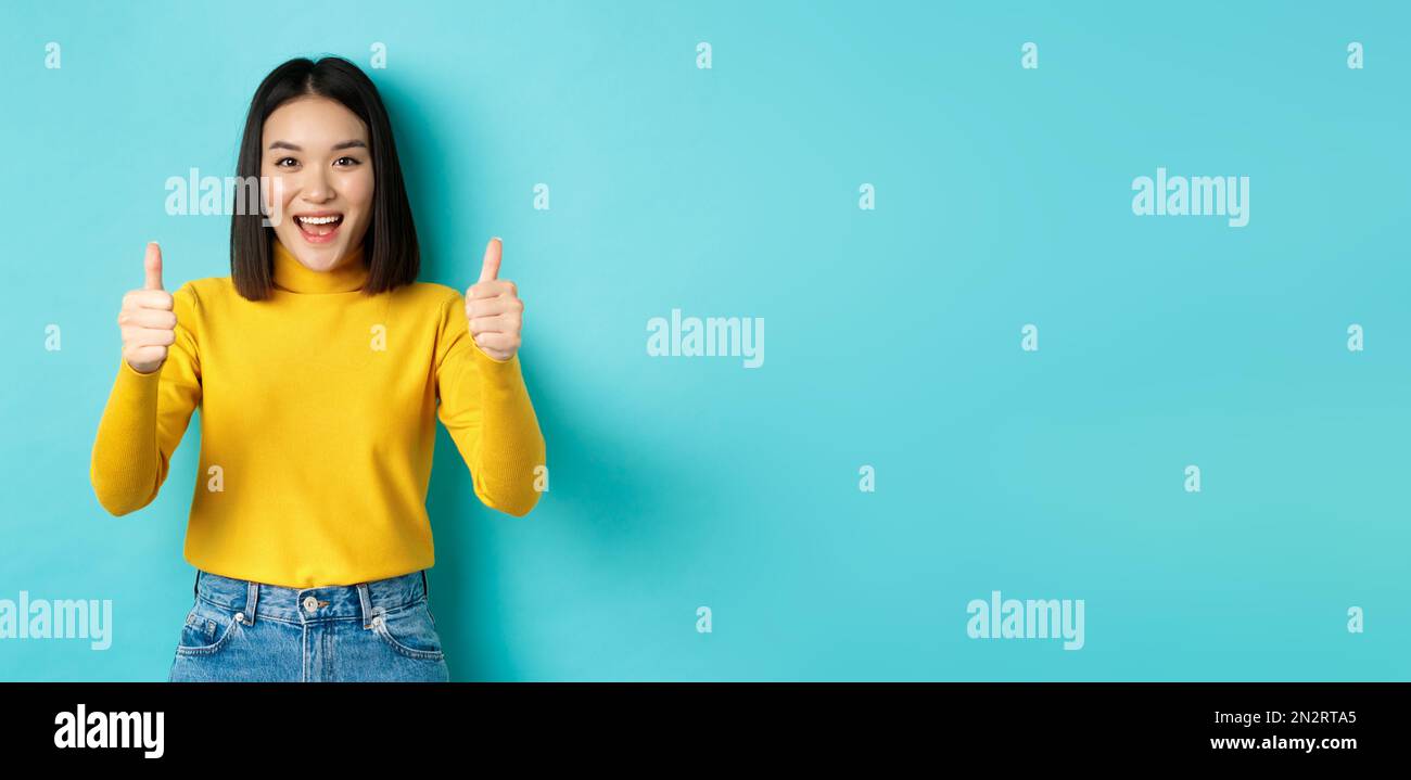 Beautiful asian woman praise good work, showing thumbs up gesture and ...