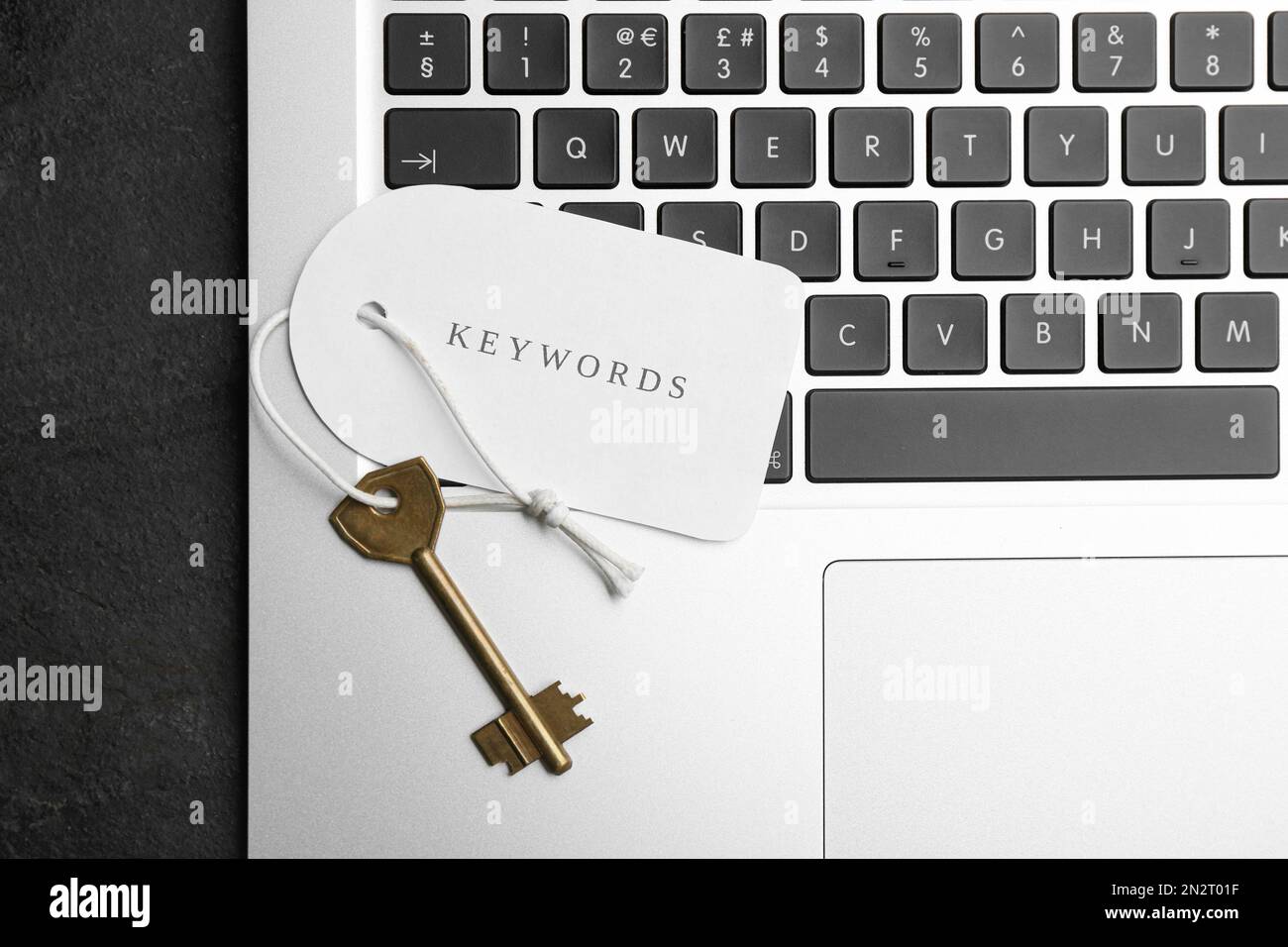 Laptop, key and tag with word KEYWORDS on black table, top view Stock ...