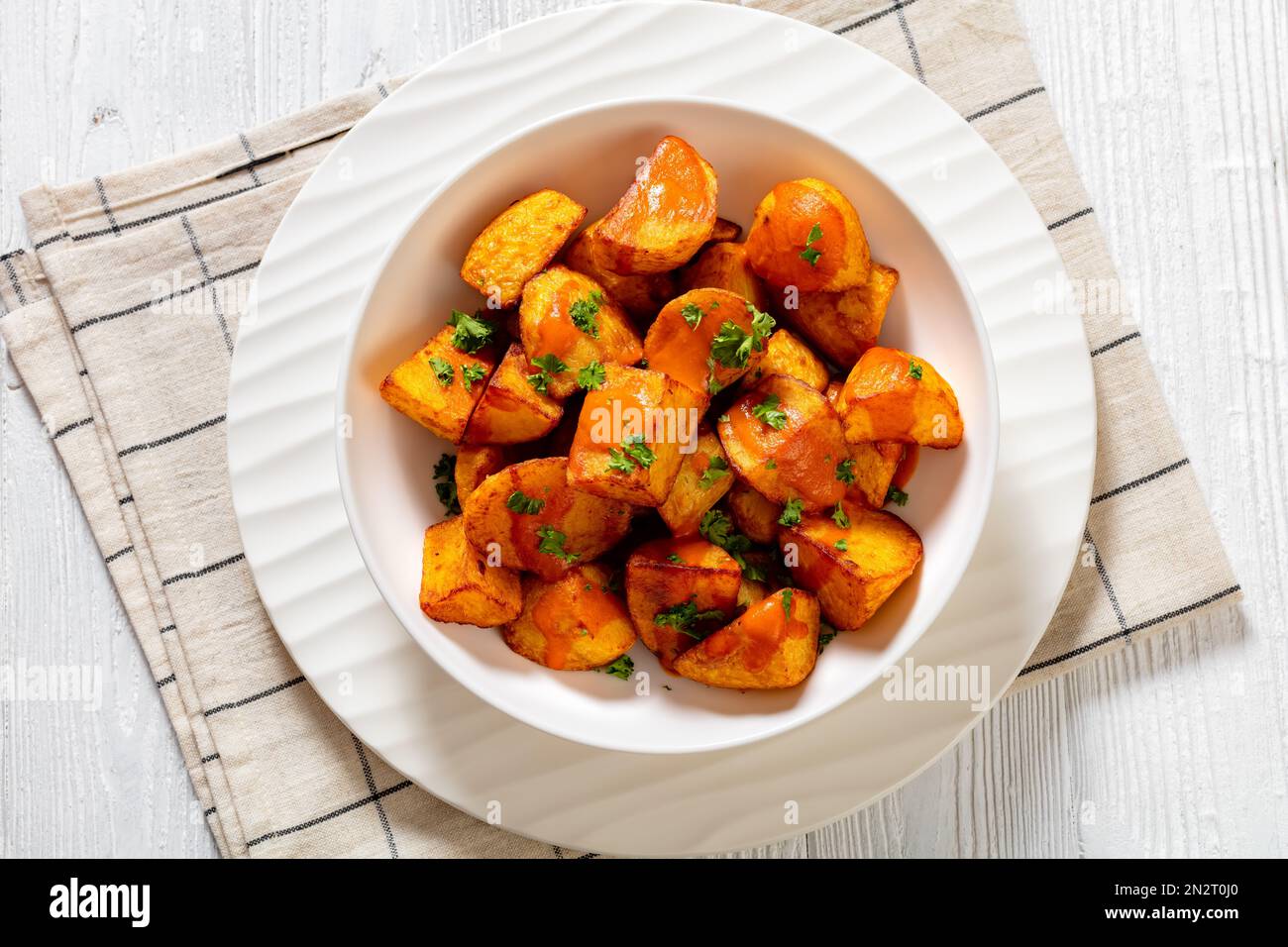 patatas bravas, deep fried potatoes with spicy sauce in white bowl on ...