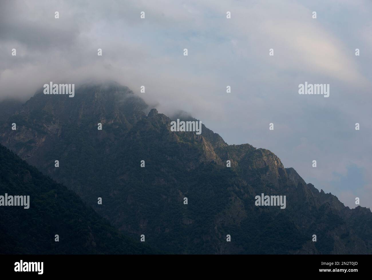 Dark atmospheric surreal landscape with a dark rocky mountain peak in ...