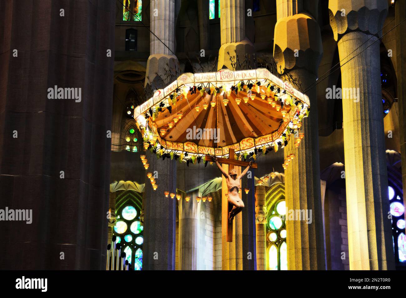 A vertical shot of a chandelier with the statue of crucified Jesus in Sagrada Familia in ...