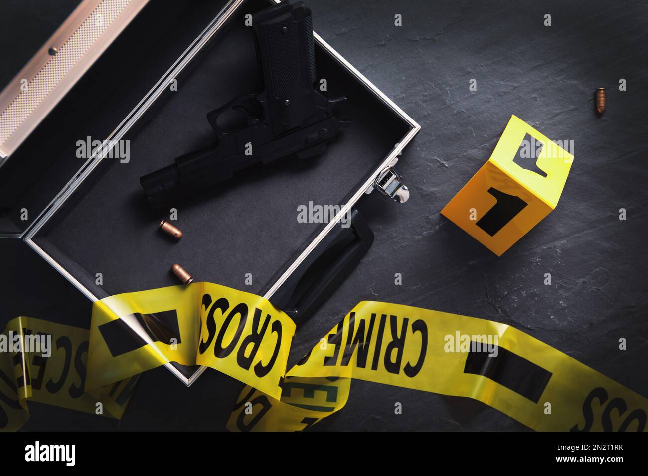 Flat lay composition with evidences and crime scene tape on black slate ...