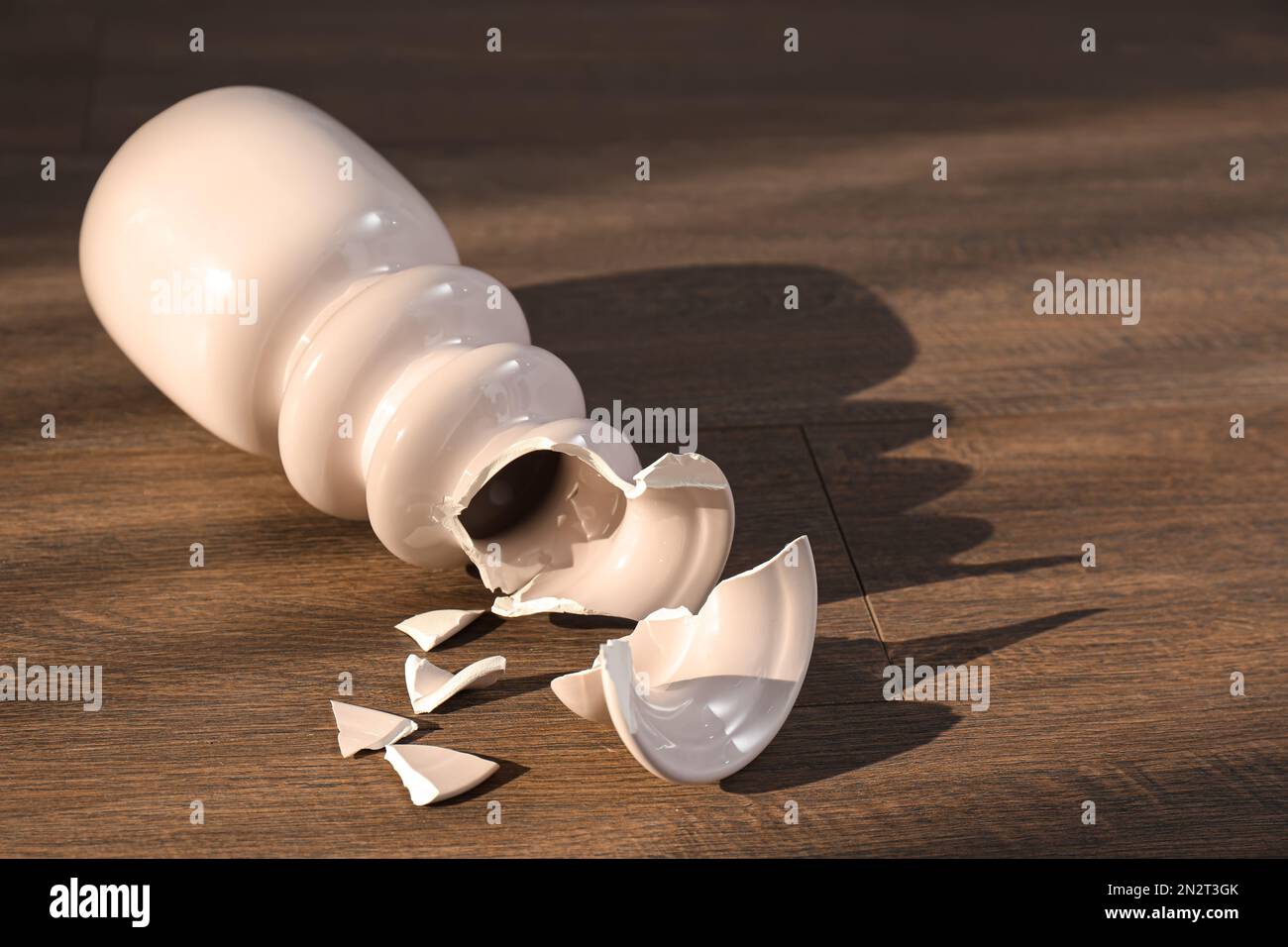Broken pink ceramic vase on wooden floor Stock Photo - Alamy