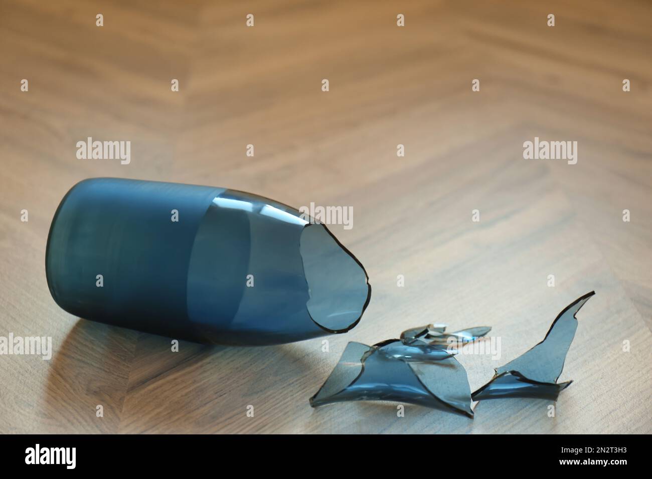 Broken blue glass vase on wooden floor, closeup Stock Photo - Alamy
