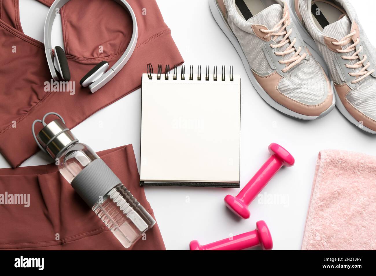 Flat lay composition with sportswear, notebook and dumbbells on white ...