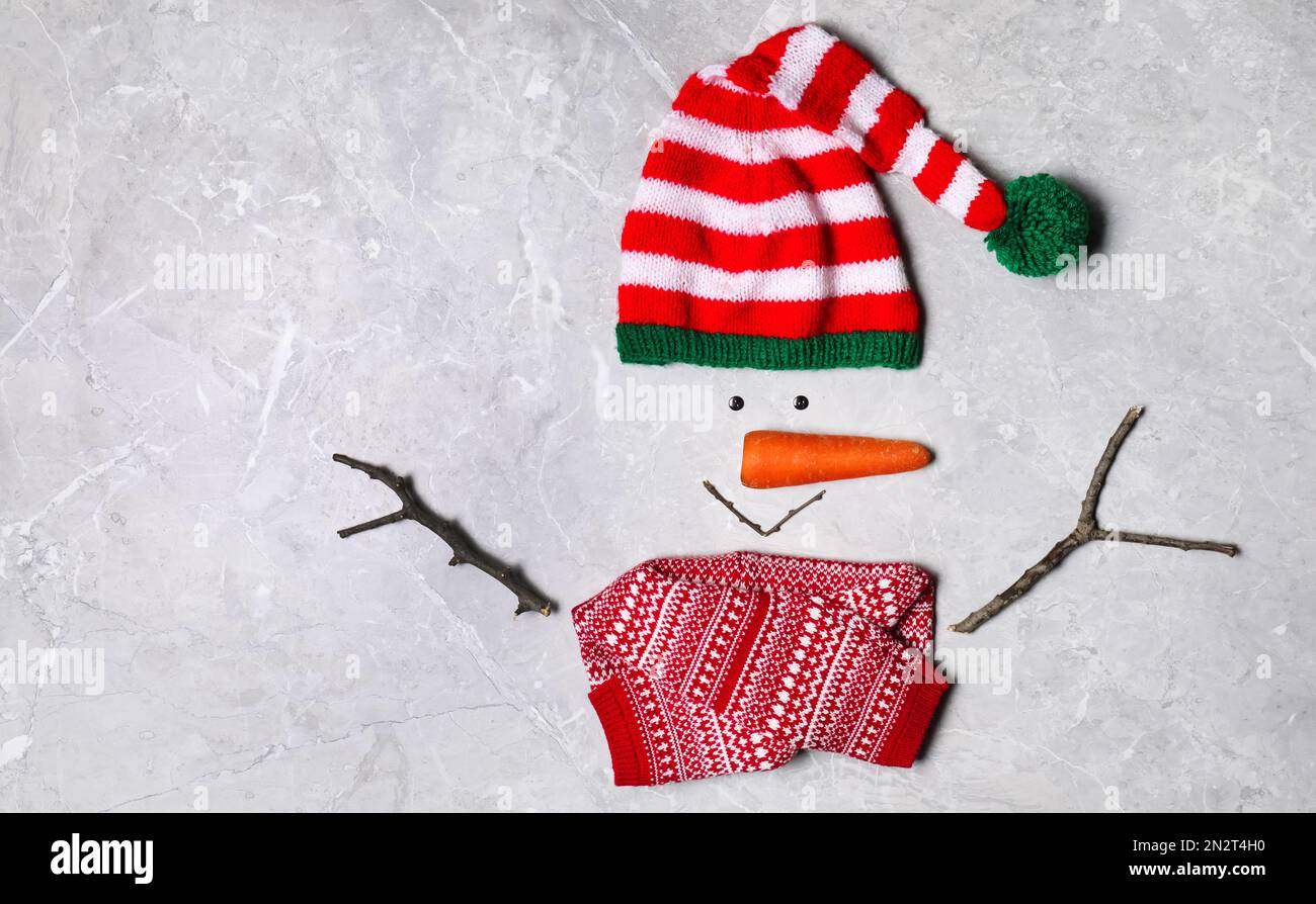 Funny snowman made with different elements on light grey marble ...
