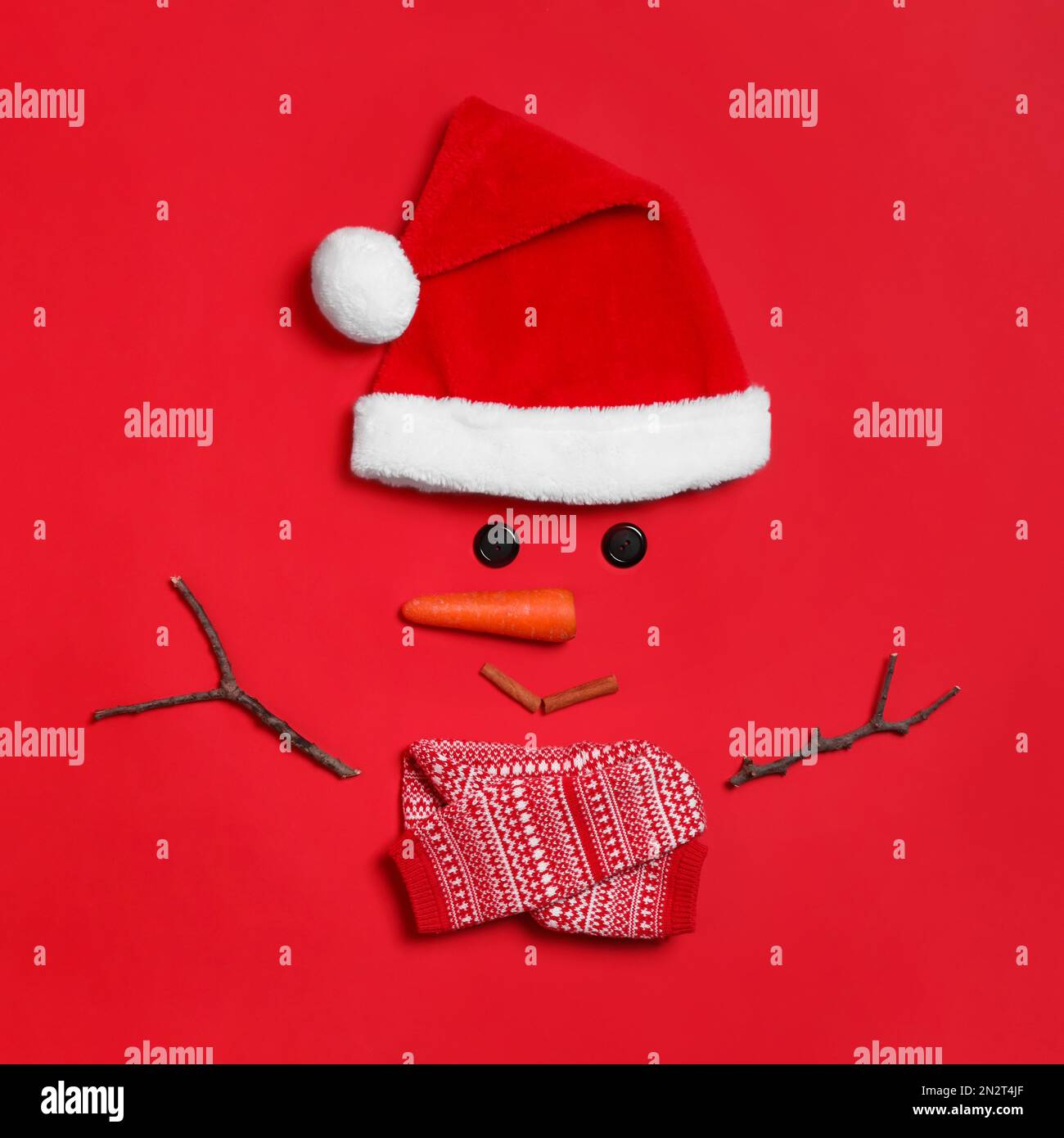 Funny snowman made with different elements on red background, flat lay ...