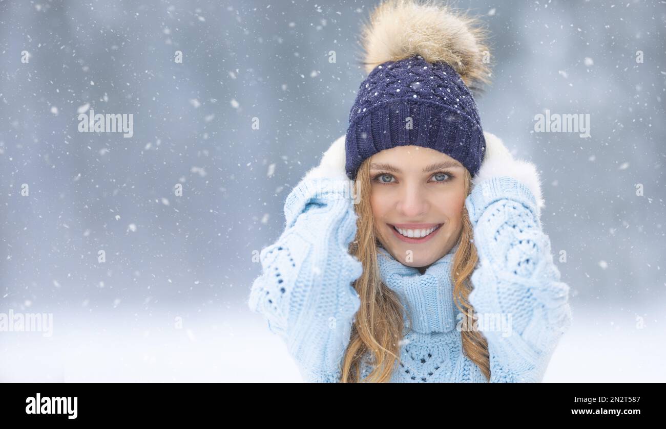 Joy and good mood of a young lady in a winter outfit in a snowy park ...