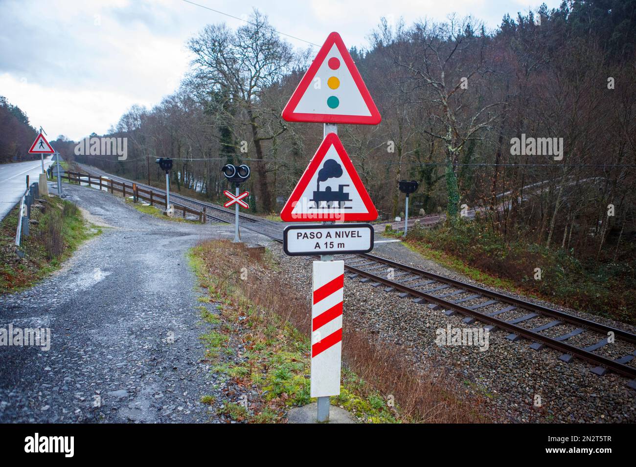 railway level crossing with warning signs that indicate the passage of ...
