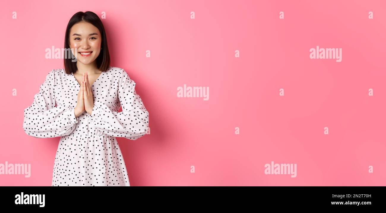 Beautiful asian woman thanking you, holding hands together in ...