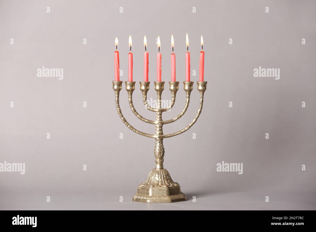 Golden menorah with burning candles on light grey background Stock ...