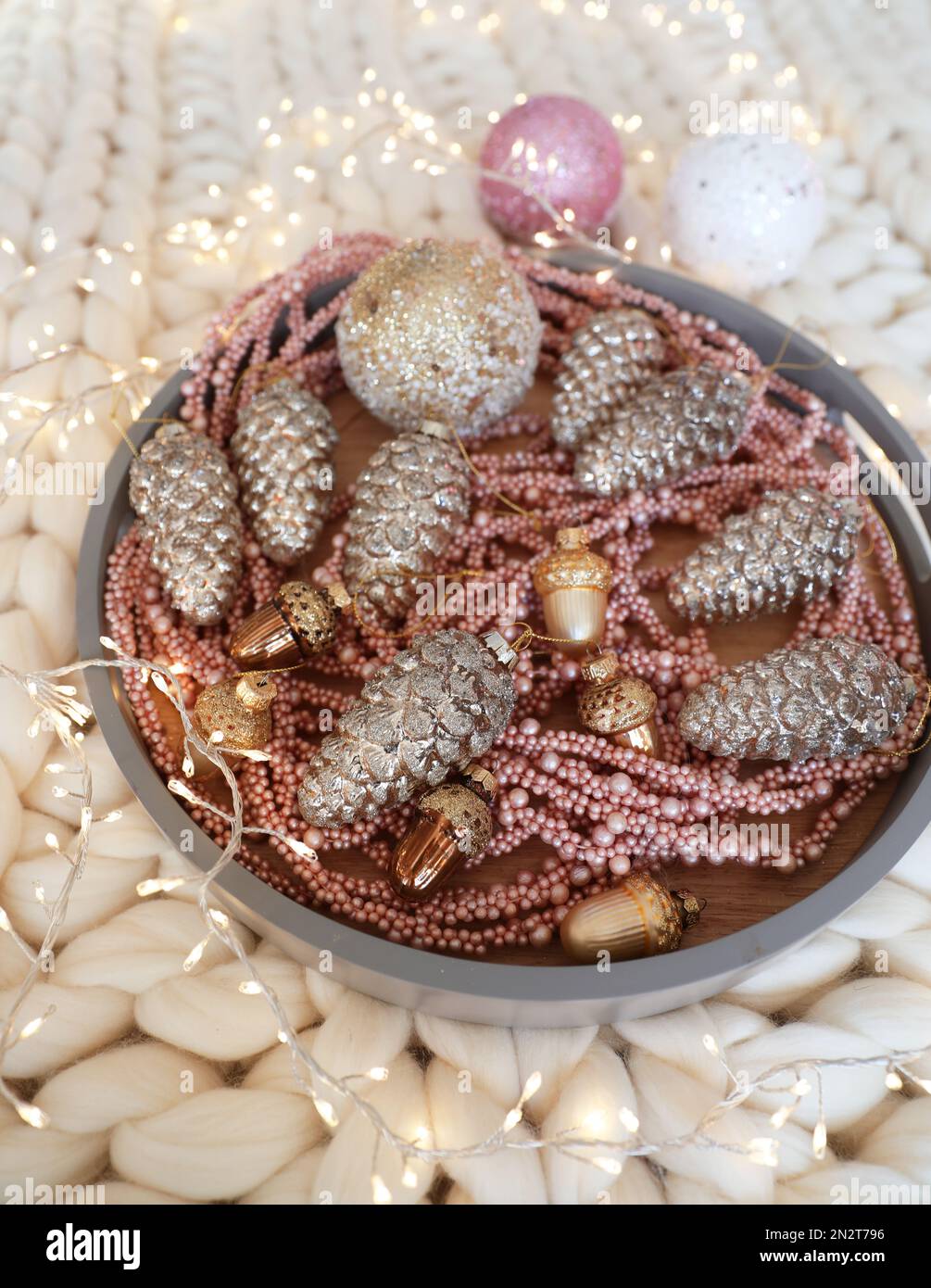 Beautiful Christmas tree baubles and fairy lights on white knitted ...