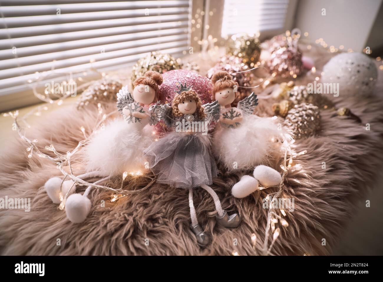 Beautiful angel dolls and shiny bauble on window sill indoors Stock ...
