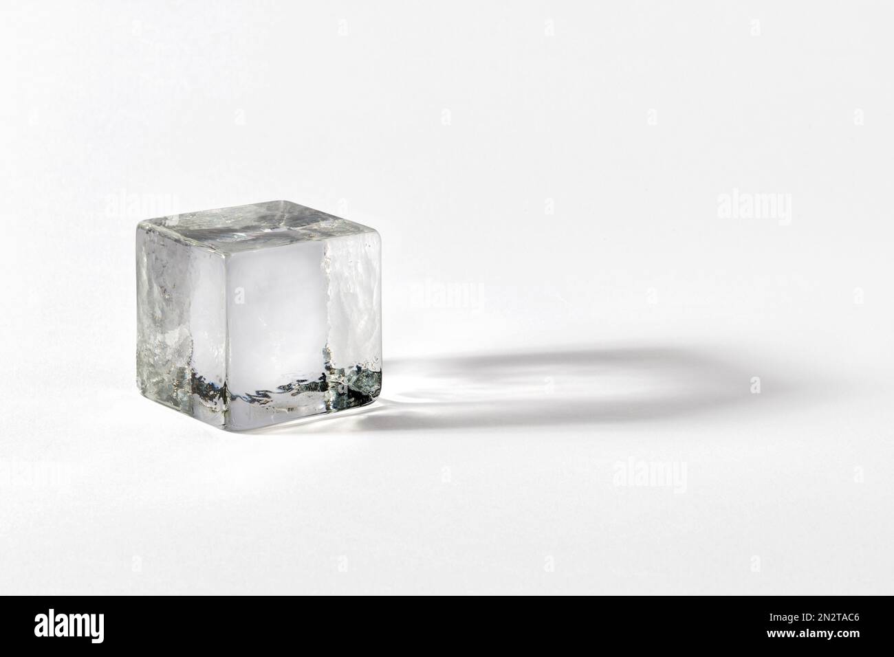 Clean crystal cube made of transparent fragile glass casting shadow on ...