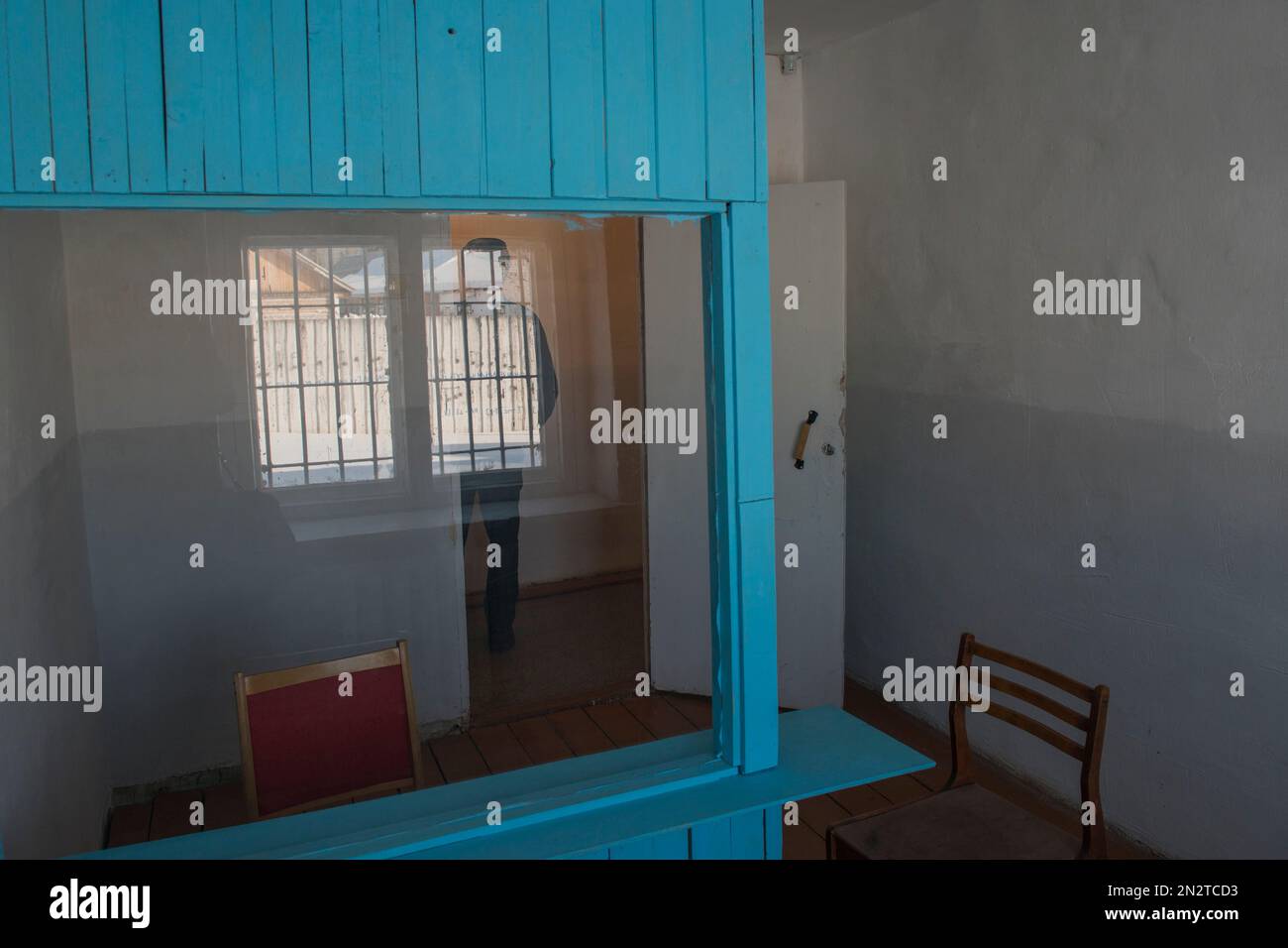 A visitor is reflected in a glass of a meeting room in a museum ...