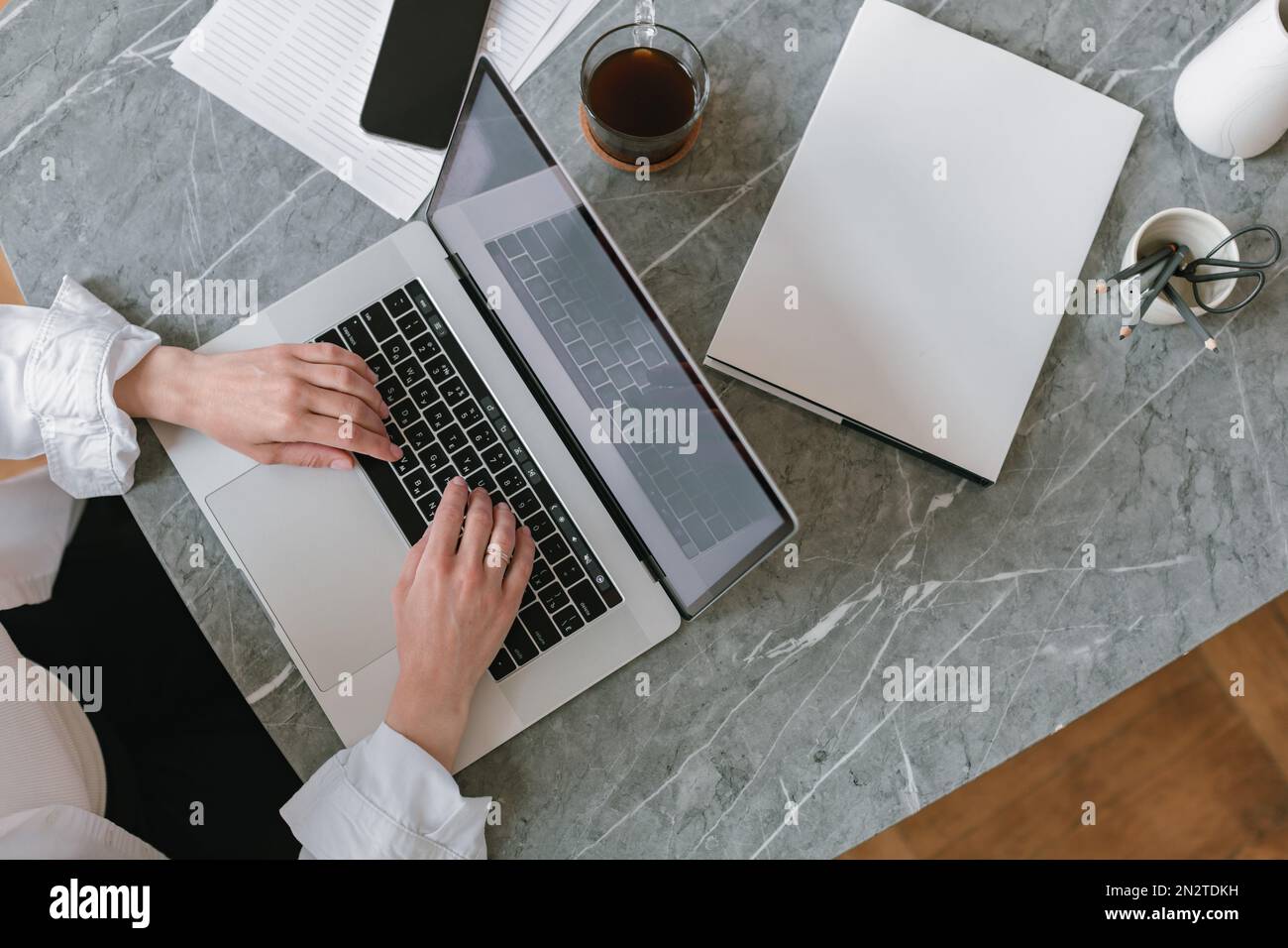 Overhead view of a woman sitting at a desk working on her laptop Stock ...