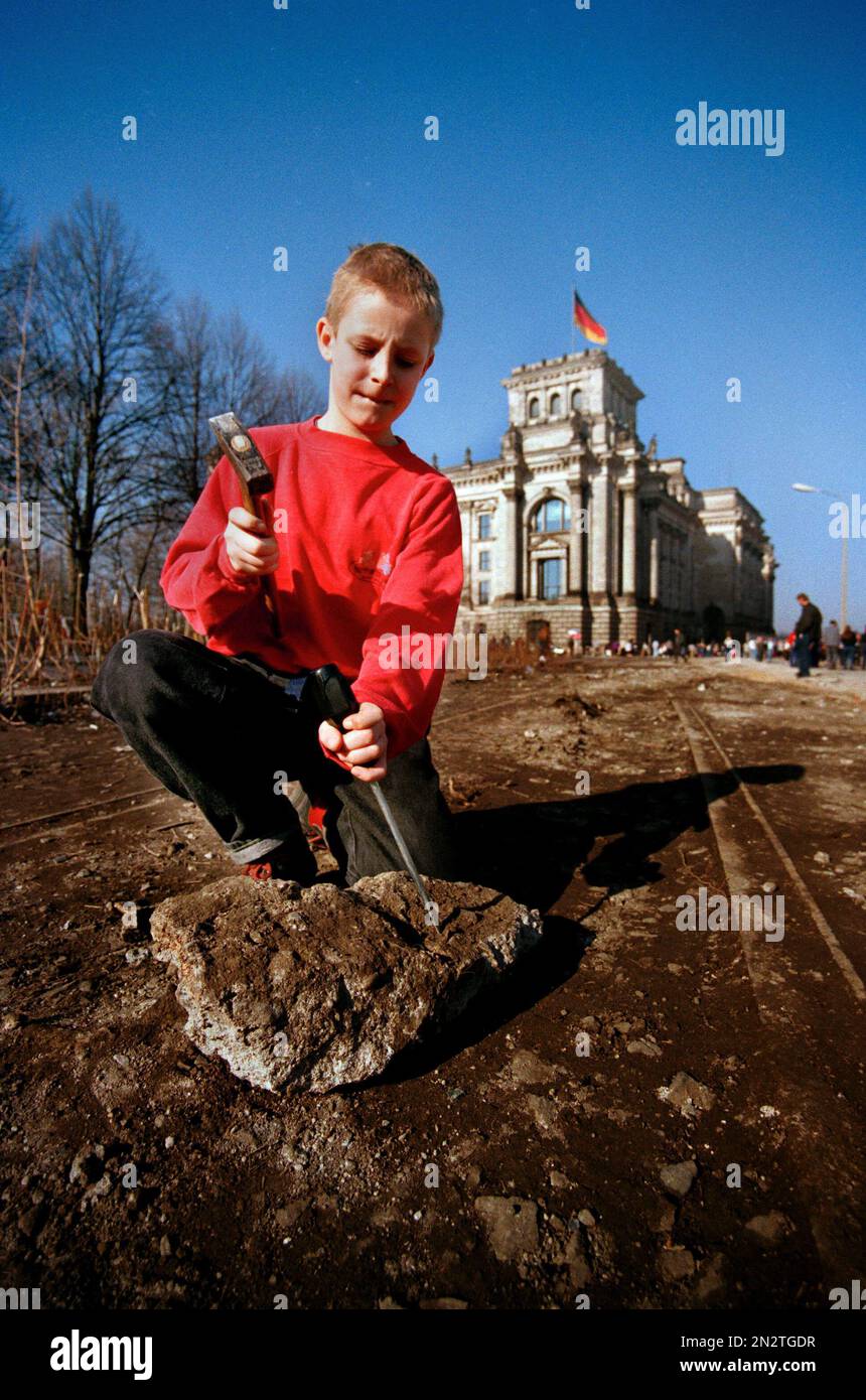 Tobias, 10-year-old East German from Frankfurt an der Oder, sits on piece of the former Berlin ...