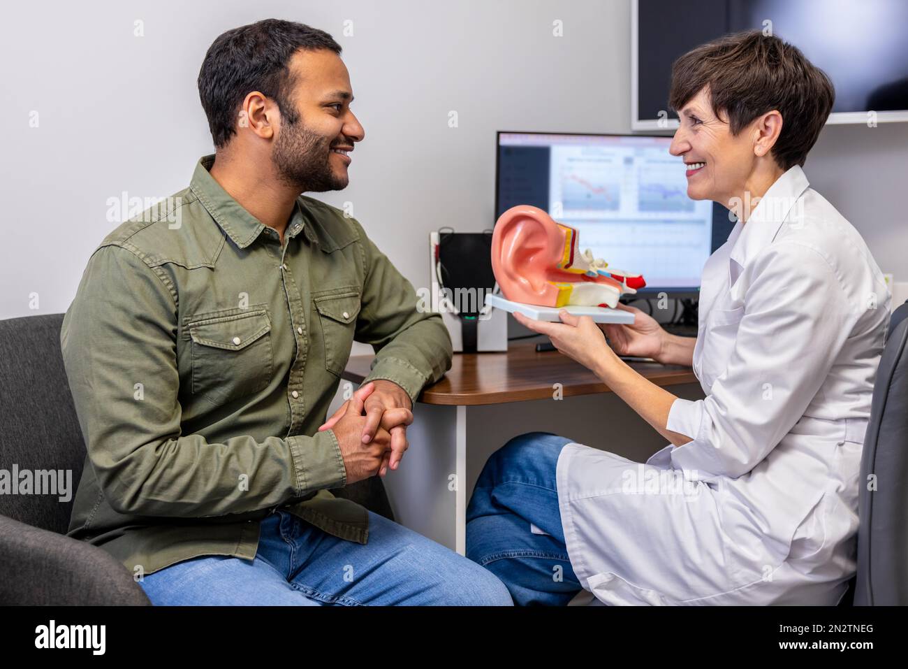 ENT doctor showing ear model to the patient and explains Stock Photo ...