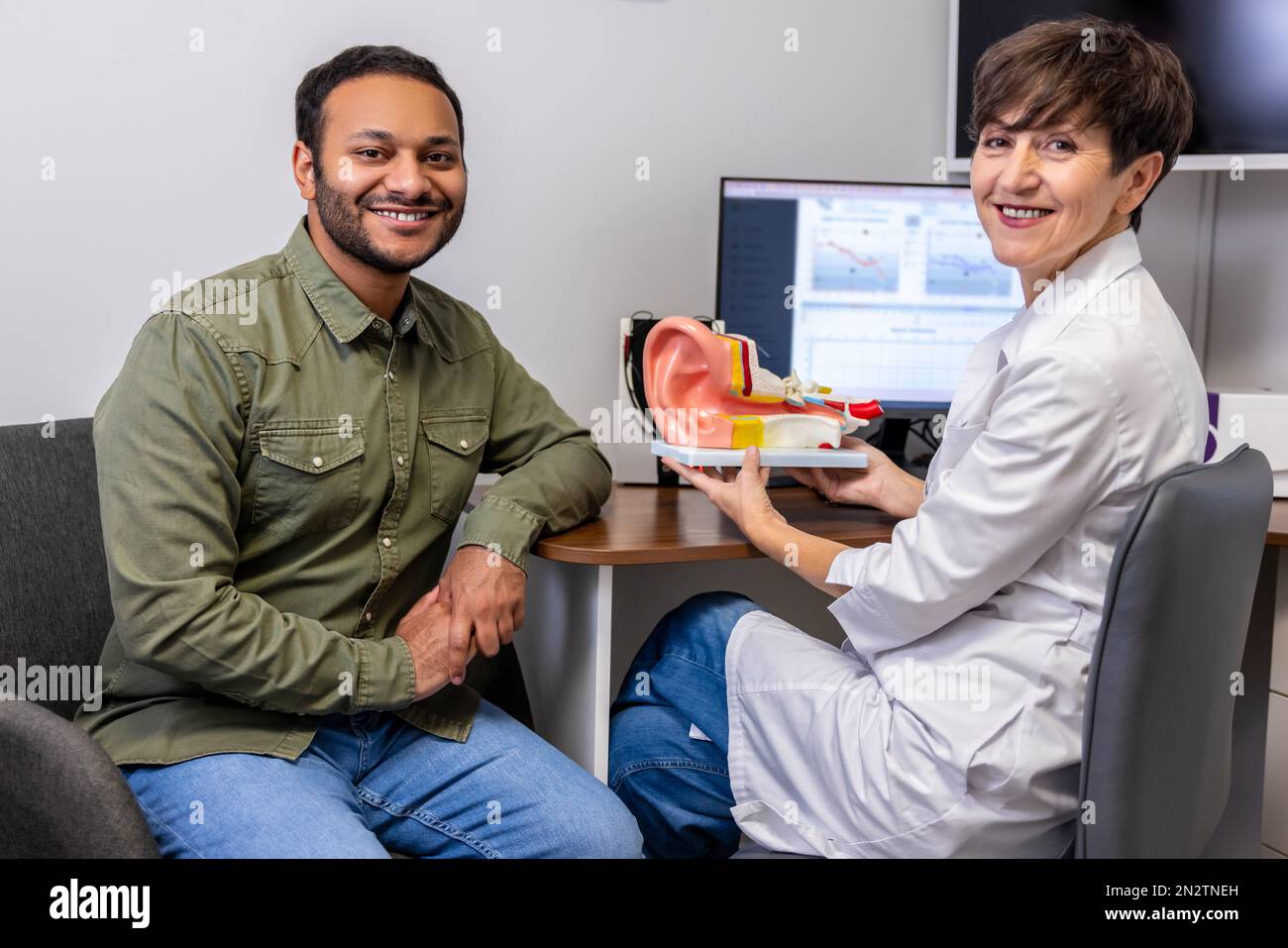 ENT doctor showing ear model to the patient and explains Stock Photo ...