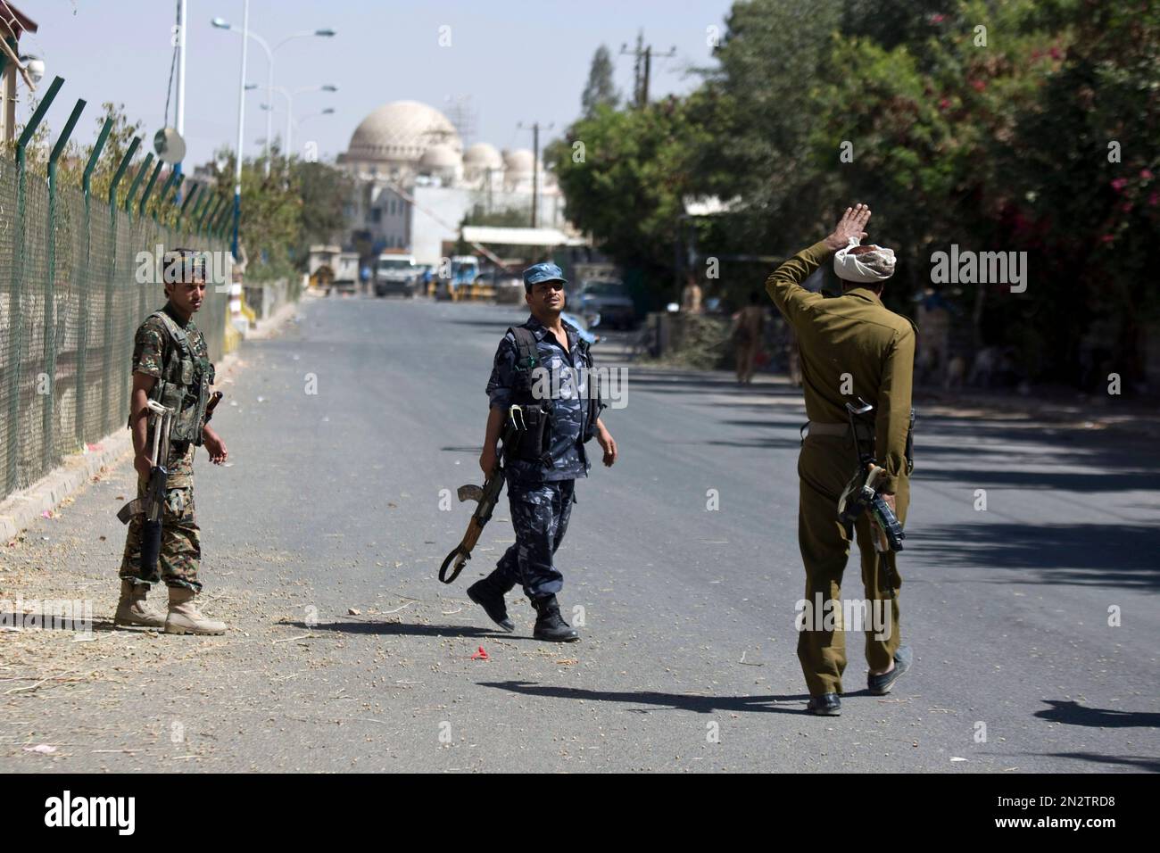 Houthi fighters wearing army uniforms, stand guard near the closed U.S ...