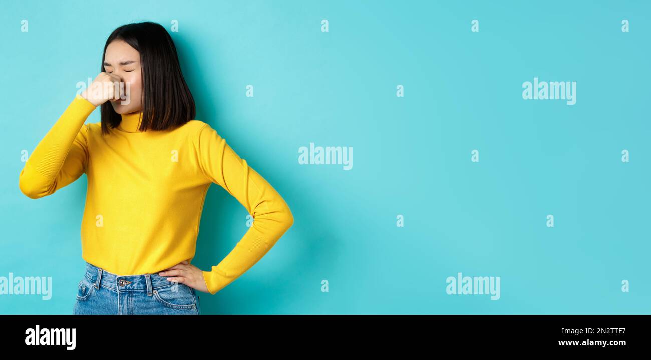 Image of asian stylish girl shut her nose and grimacing from aversion ...