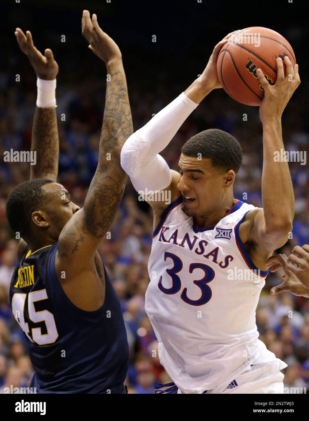 Kansas forward Landen Lucas (33) drives on West Virginia forward Elijah ...