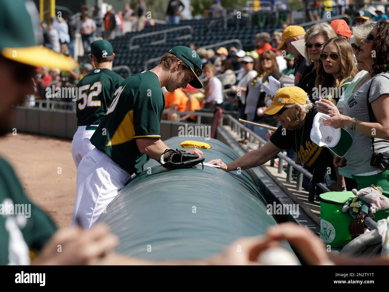 Oakland Athletics' Mark Canha (20) signs autographs for a fan before a ...
