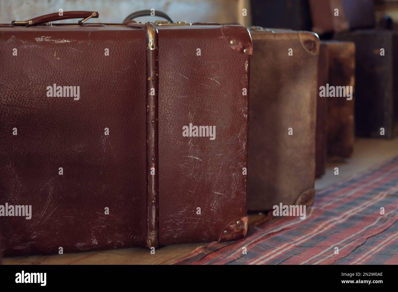 Row of antique shabby suitcases on floor of wooden countryside house ...