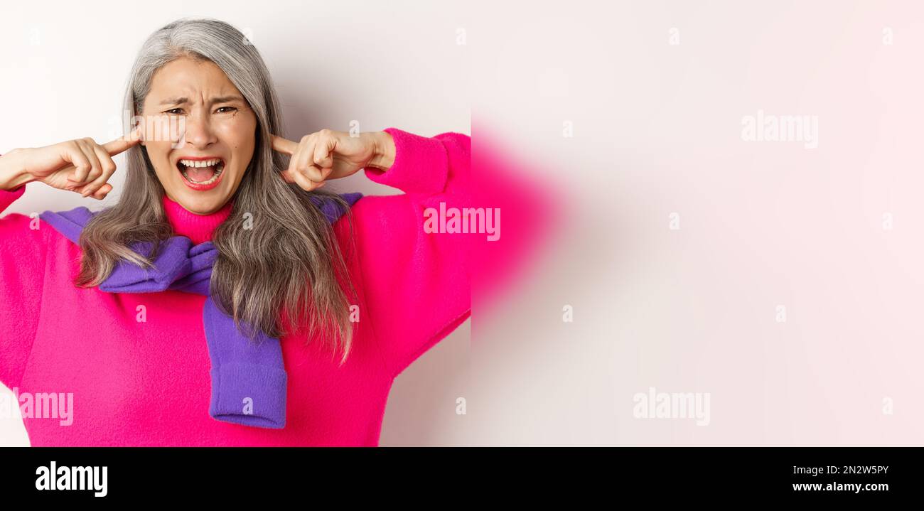 Close Up Of Annoyed And Bothered Asian Senior Woman Screaming With Shut