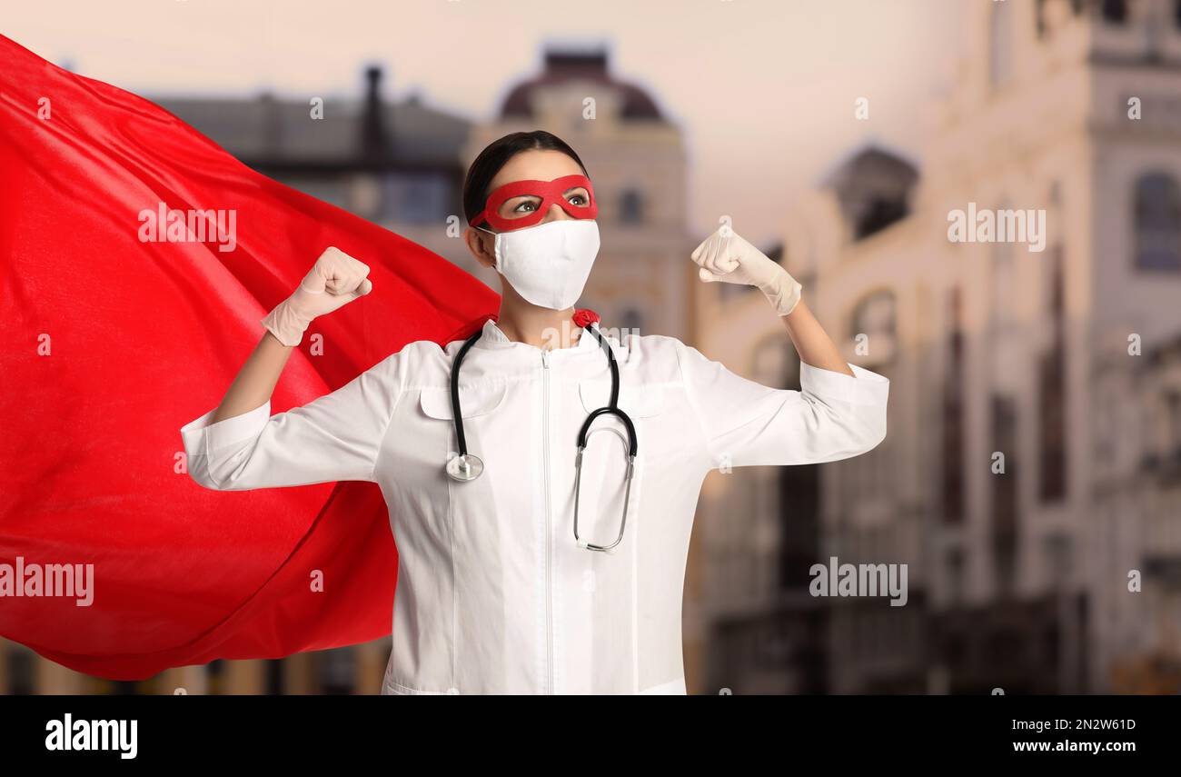 Doctor dressed as superhero on city background. Medical workers ...