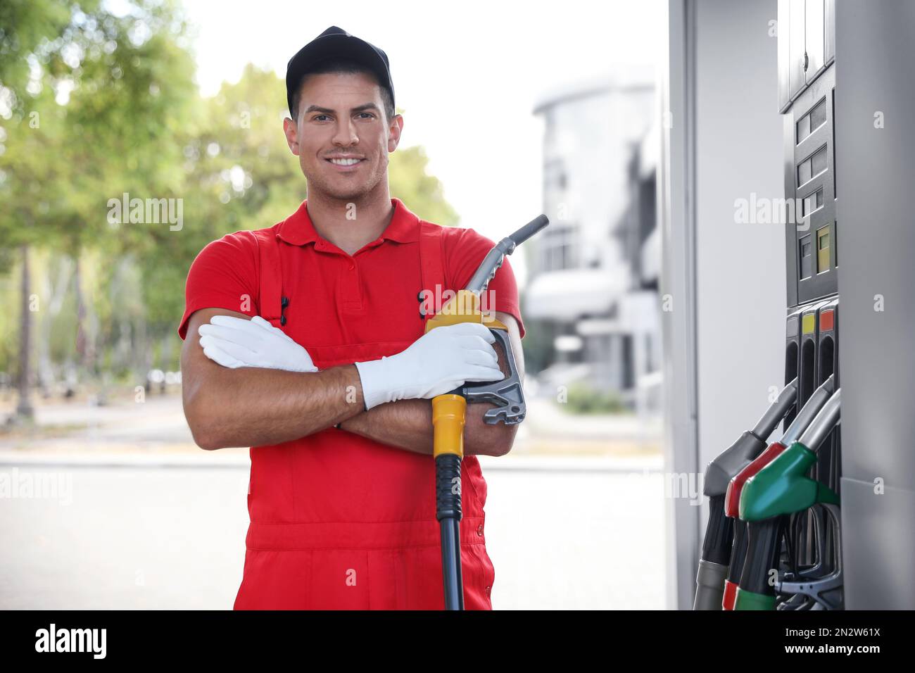 Worker with fuel pump nozzle at modern gas station Stock Photo - Alamy