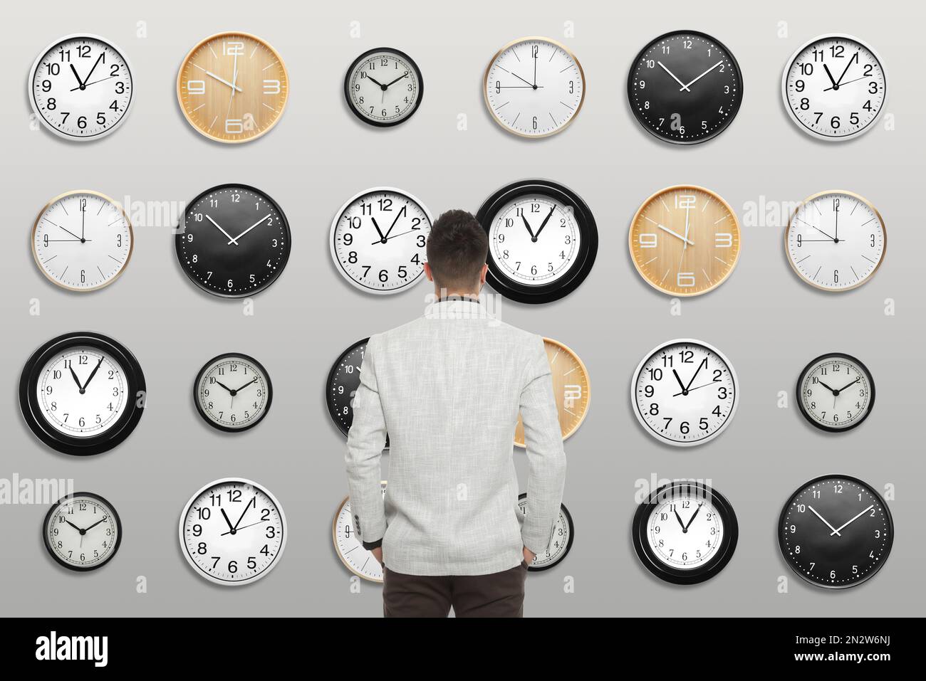 Time management concept. Businessman standing in front of different ...
