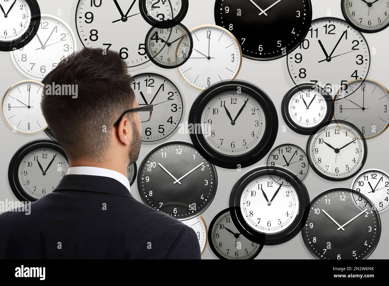 Time management concept. Businessman standing in front of different ...