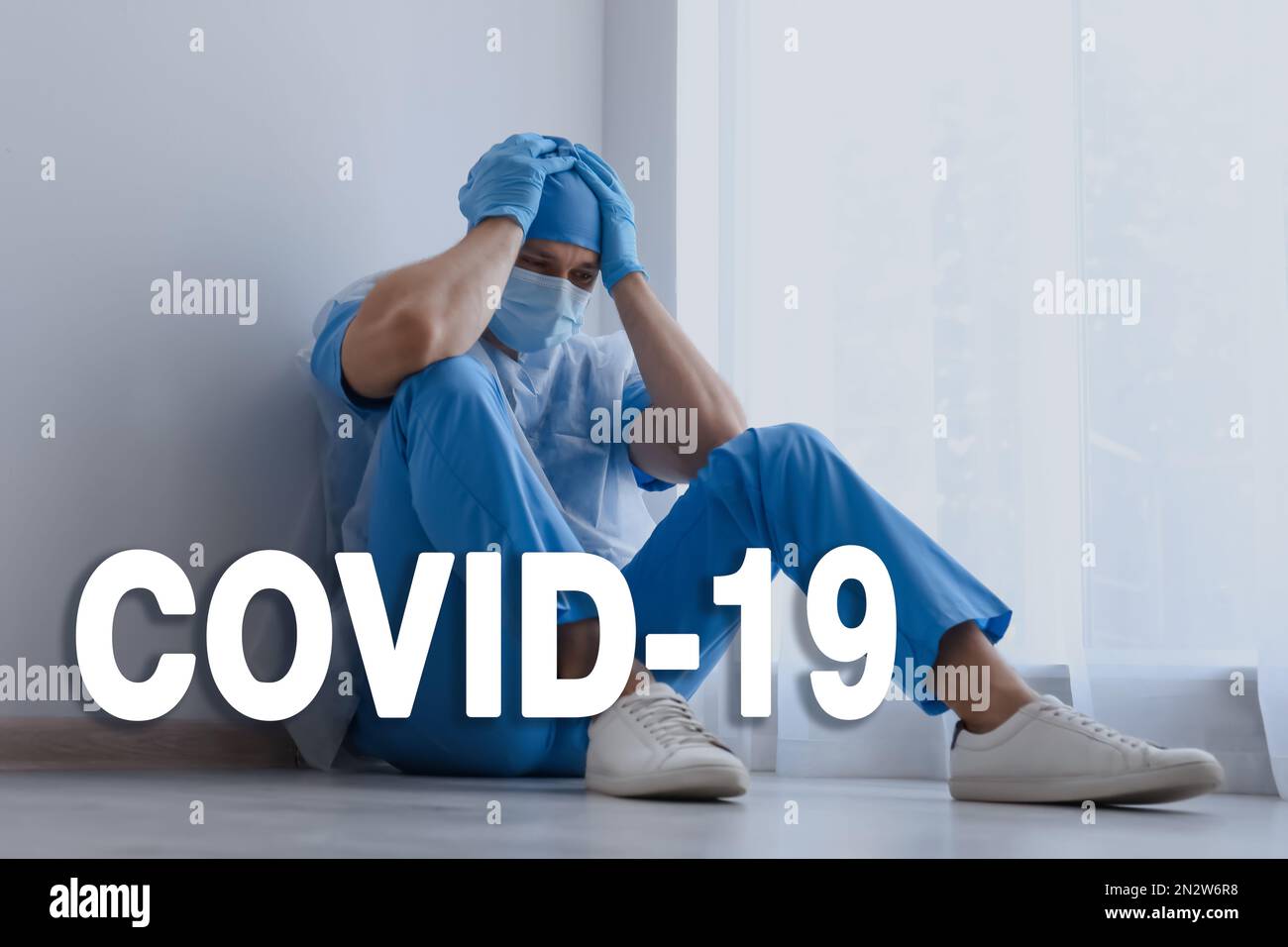 Tired overwhelmed doctor sitting on floor in hospital. Medical system ...