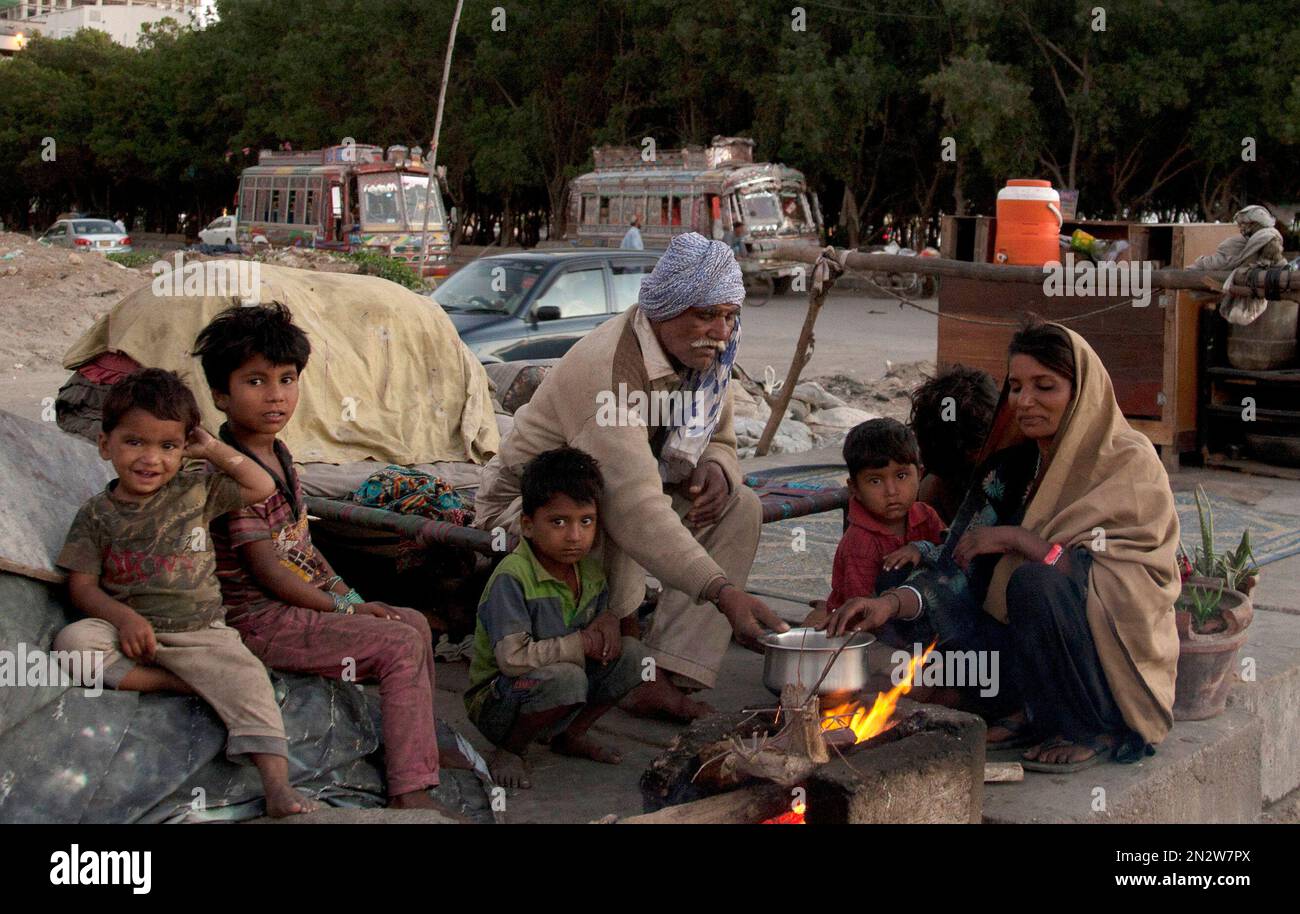 A homeless Pakistani family cooks on the side of a road roadside in ...
