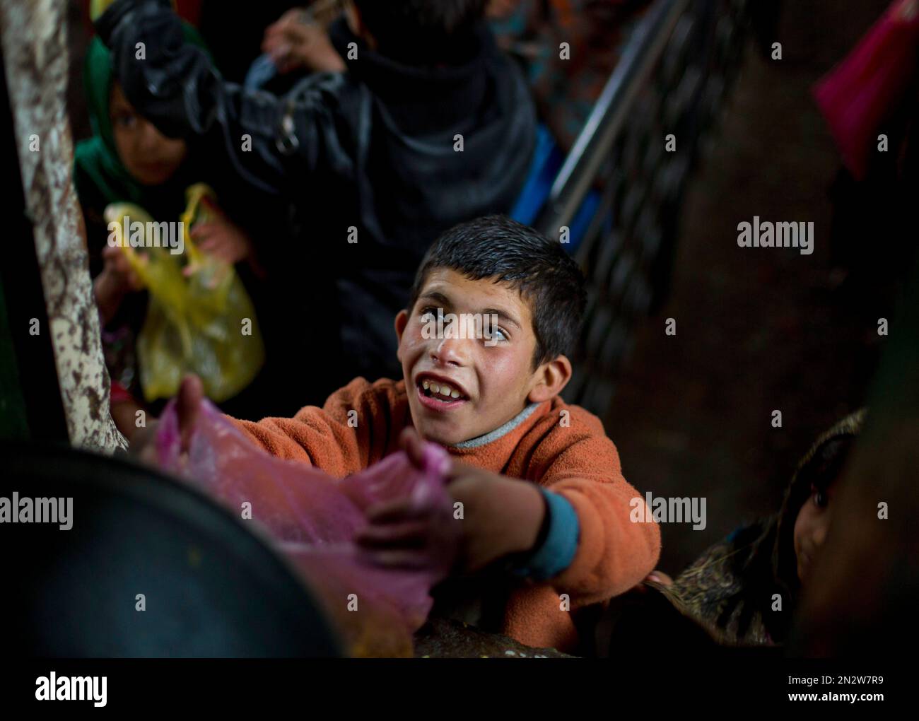 A Pakistani boy receives free food distributed at the shrine of Sufi ...