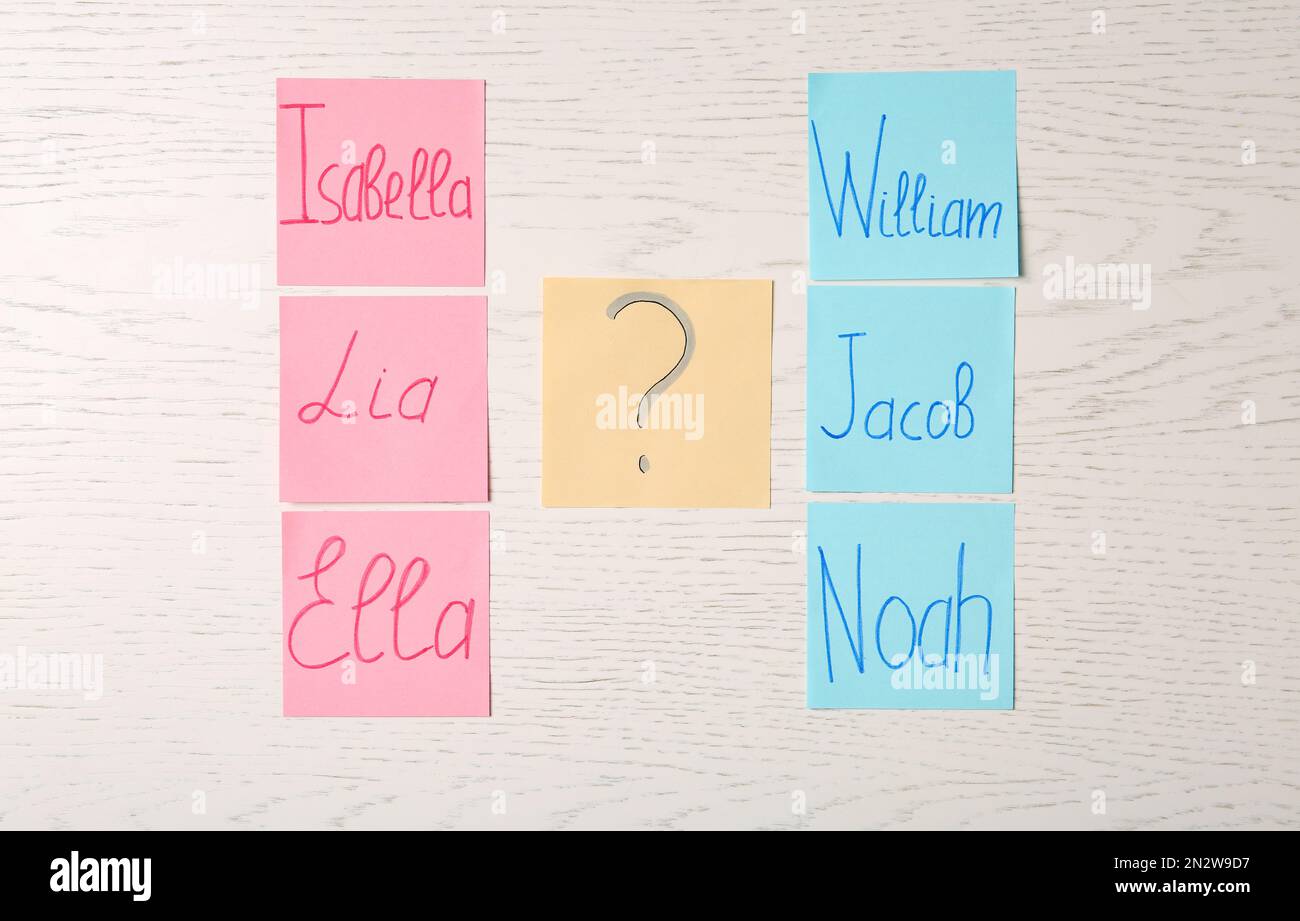 Colorful sticky notes with written baby names on white wooden ...